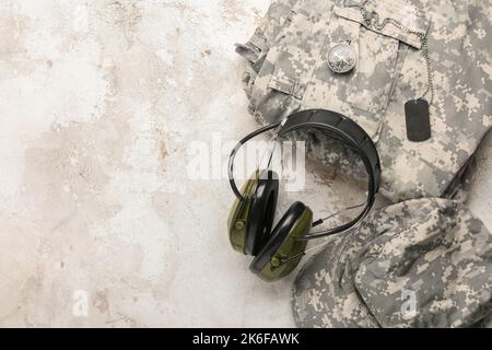 Military uniform, tag, compass and headphones on light background Stock ...