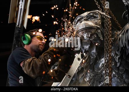 Sculptor Luke Perry applies finishing touches with an angle grinder to ...