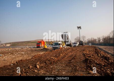 Municipal waste landfill. Workers with trucks and bulldozers at work in ...