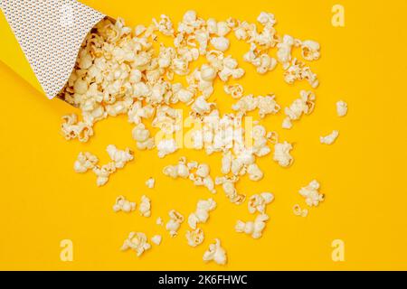Snack concept, Sweet popcorn spilled out from paper cup on red ...