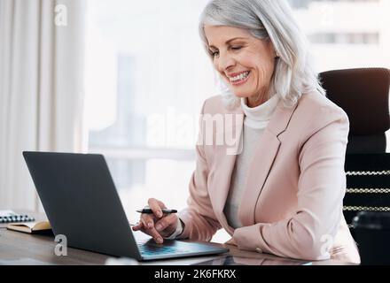 Always an email away. a mature businesswoman sitting alone in the ...