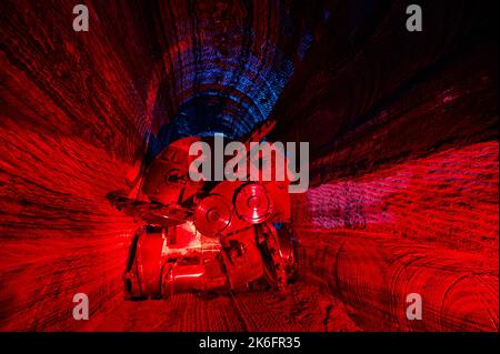Illuminated mining drilling machine in salt quarry tunnel Stock Photo ...