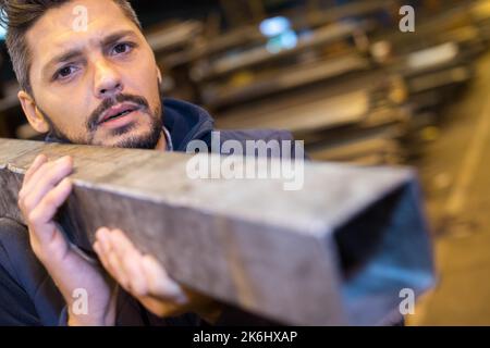 construction worker carrying reinforcement rods at building site Stock ...