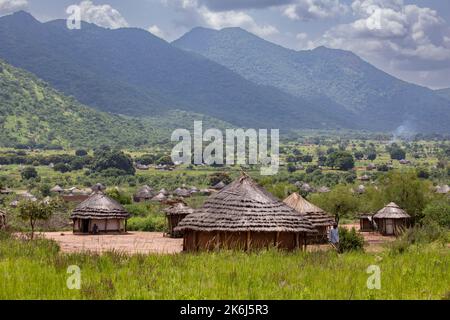 Beautiful grass thatch mud houses lay in a valley below the hills and ...