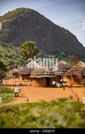 Beautiful grass thatch mud houses lay in a valley below the hills and ...