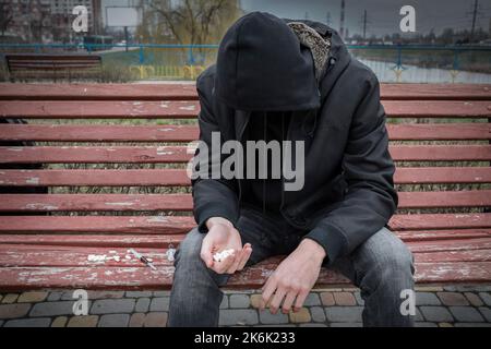 A drug addicted homeless man sitting alone and depressed in an ...