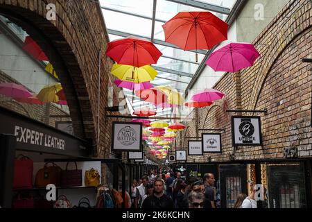 Camden Market inside shops on a sunny day with colourful umbrellas ...