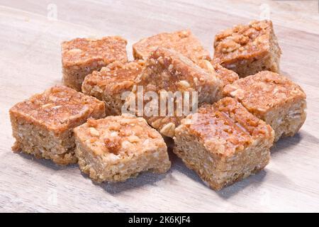 Ten oatmeal flapjacks crumbley and ready to eat along with a mug of ...