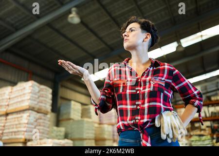 Thoughtful female storekeeper looking for tedious goods in building ...