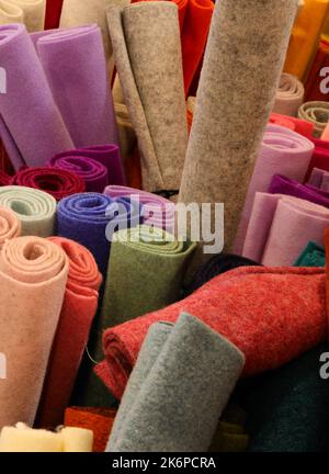 tubes of fabrics and colorful cloths and for sale in the cloth shop ...