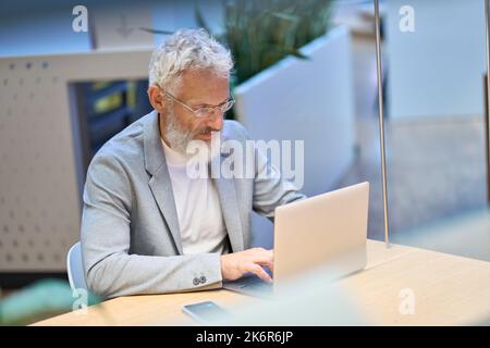 Old businessman employee sitting at workplace Stock Photo - Alamy