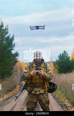 An artillery spotter or military observer launches a drone into the sky ...
