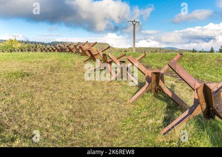 anti tank metal fortifications and hedgehogs on green grass, pieces of ...