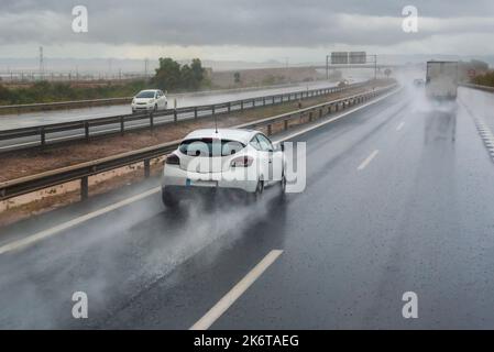 Vehicles circulating on a highway flooded by water falling from a heavy ...