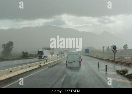 Vehicles circulating on a highway flooded by water falling from a heavy ...