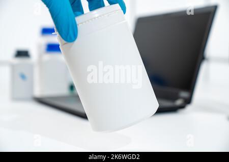 Plastic container for chemicals in science lab on computer background ...