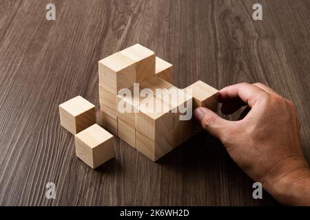 Human hand builds stack of wooden blocks. Business strategy conceptual ...
