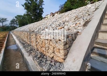 Completed slope retention construction design with rocks and mesh to ...