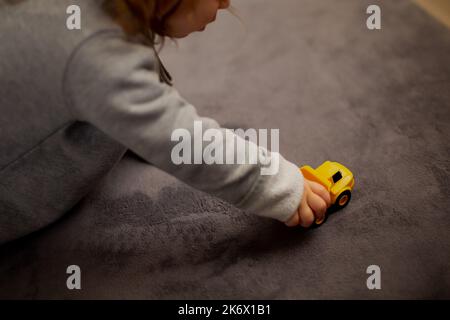 Adorable toddler playing with car toy sitting on table at kindergarten ...