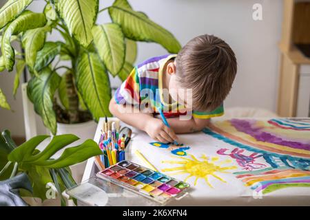 Confident cute male kid art drawing multicolored rainbow arch use ...