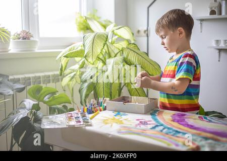 Confident cute male kid art drawing multicolored rainbow arch use ...