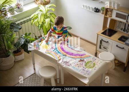 Confident cute male kid art drawing multicolored rainbow arch use ...