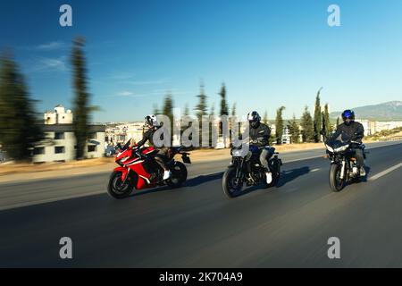 Three supersport race motorcycle riders going fast side by side on the ...