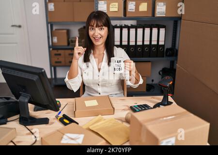Young brunette woman standing by manikin at small business holding i am ...