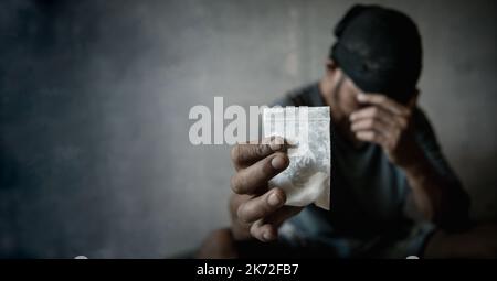 Drug addiction. Man with plastic bag of cocaine on grey background ...