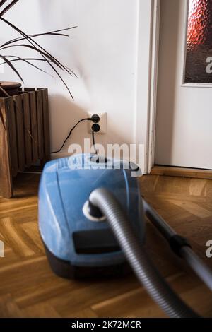 Vacuum cleaner plugged in wall outlet Stock Photo - Alamy
