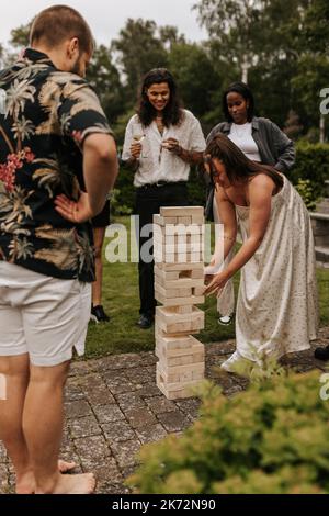 Group of friends playing with jenga game in rooftop on a summer party ...
