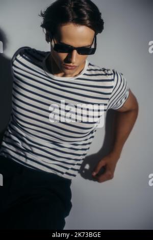 A high-angle shot of a gray striped cat looking straight into the ...