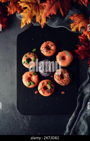 Homemade Mini autumn donuts with orange frosting, selective focu Stock ...