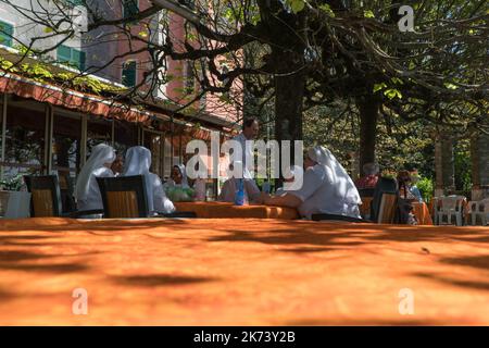 A group of Roman catholic nuns sat around a table chatting, Montallegro ...