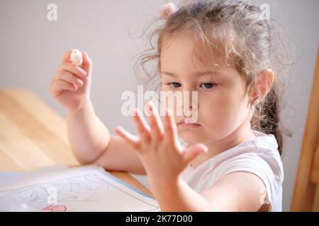 Little girl playing iwth invisible ink and coloring book Stock Photo ...