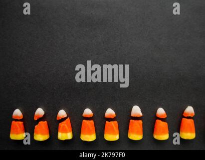 Broken candy corn look like small bad teeth. Black background. Copy ...