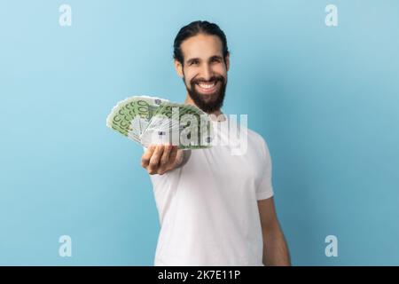 Young hispanic man holding euro banknotes smiling with an idea or ...
