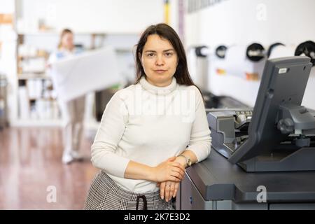 Technician operator calibrating plotter machine, typing on computer ...