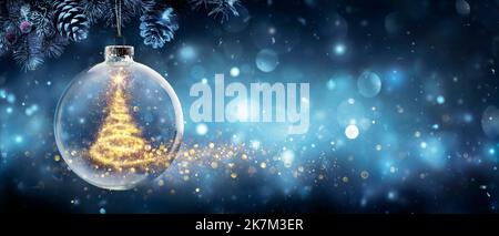 Hanging blue glitter Christmas ball on spruce and over blurred ...