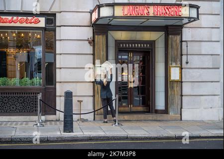 Young woman changing the outside menu display case at Langan's ...