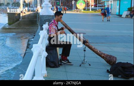 A young man playing a traditional Mayan trumpet on the promenade Paseo ...