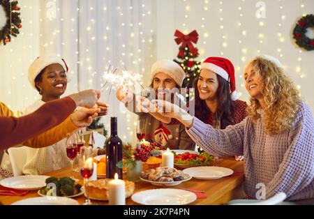 happy friends with sparklers at christmas dinner Stock Photo - Alamy