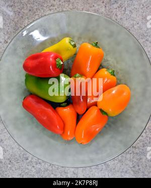 Mini bell peppers on glass plate in a granite background Stock Photo ...