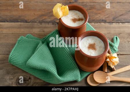 Ceramic bowls of rice pudding and cinnamon with decoration on wooden ...