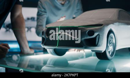 Senior automotive engineers discuss the car design infront of a ...