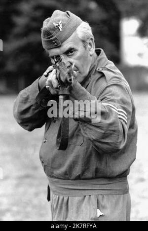 1970 British Army soldier in camouflage suit and steel helmet carrying ...