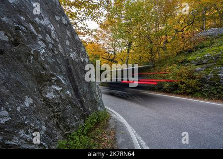 Car takes narrow bend between boulders in Smugglers Notch in the fall ...