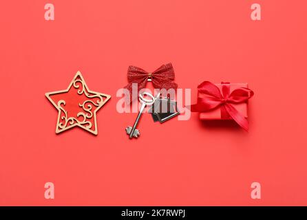 Key from new house and Christmas decor on red background Stock Photo ...