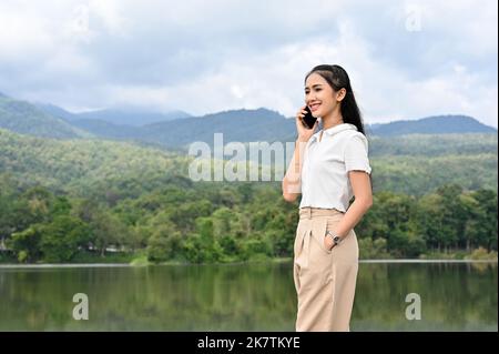 Attractive millennial Asian businesswoman or female accountant using ...