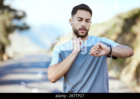 Sporty young man checking his pulse outdoors Stock Photo - Alamy